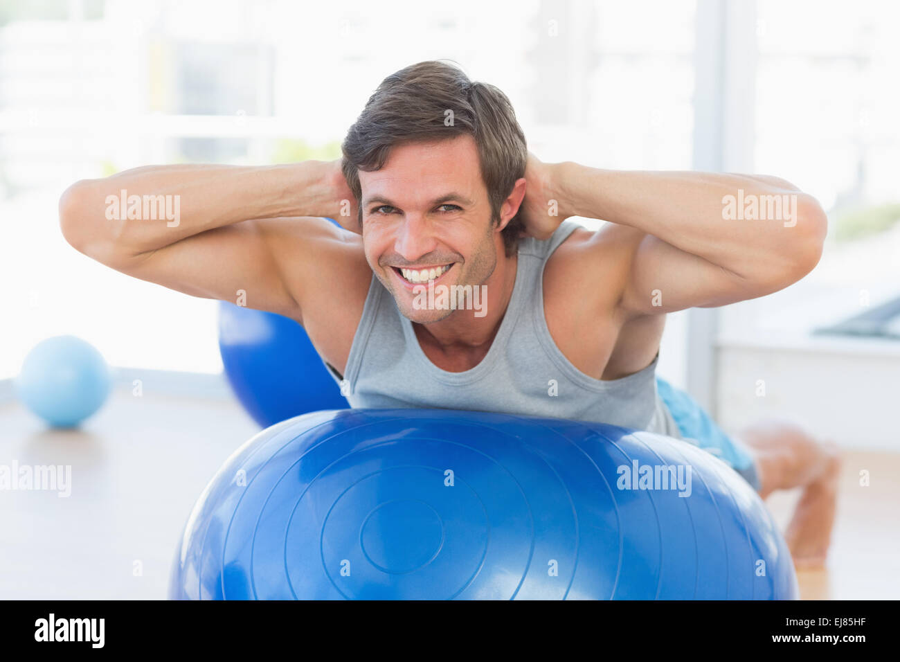 Happy fit man stretching on exercise ball Stock Photo - Alamy