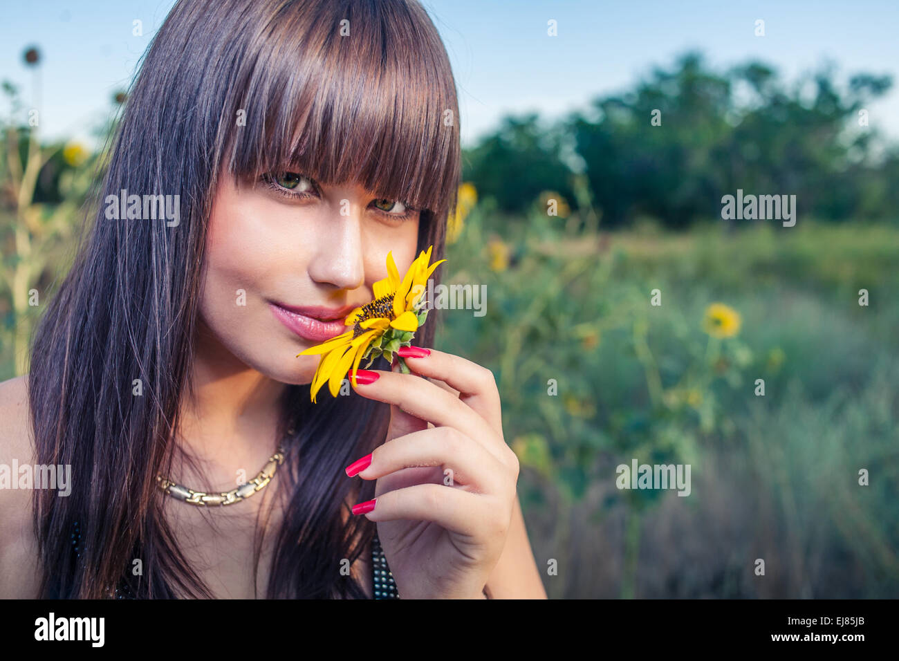 Women smelling sunflower Stock Photo - Alamy