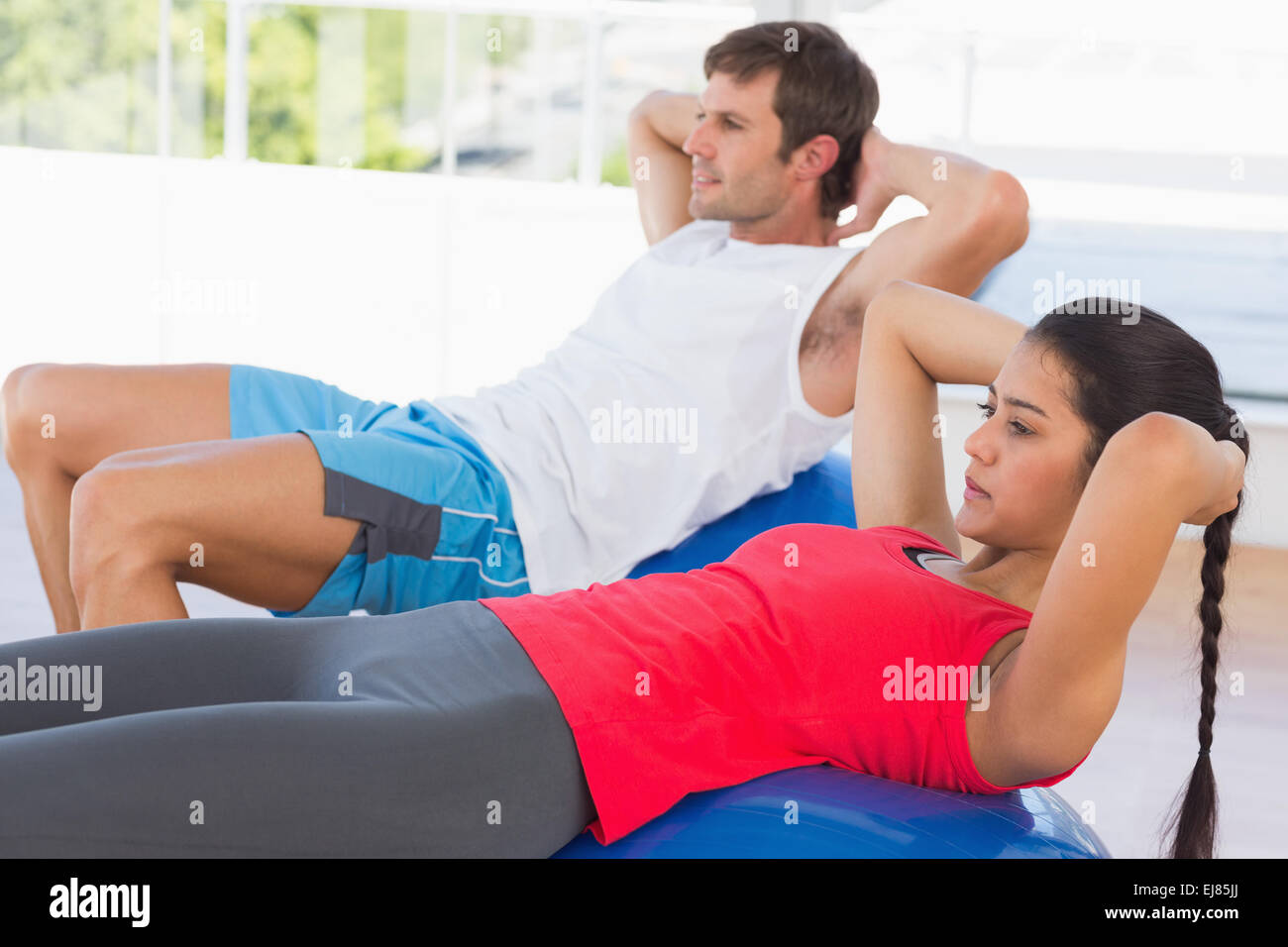 Man woman exercising on fitness balls in gym hi-res stock photography ...