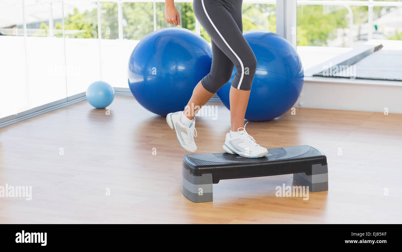 Low section of a fit woman performing step aerobics exercise Stock ...