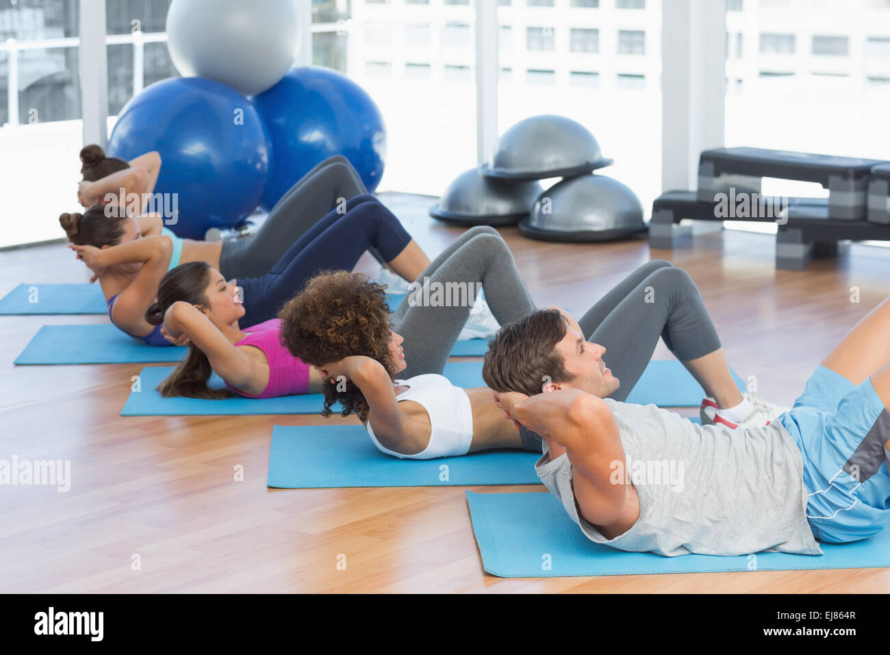 Determined people doing sit ups in fitness studio Stock Photo - Alamy