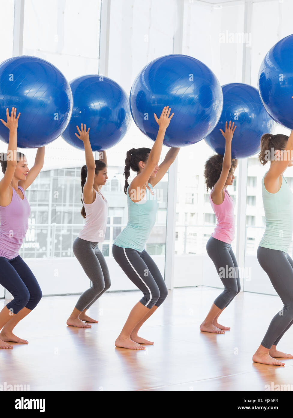 Fit women holding blue fitness balls in exercise room Stock Photo - Alamy