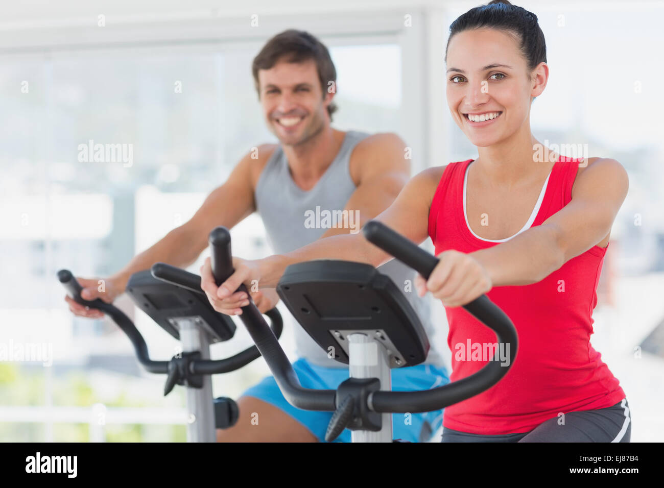 Smiling young couple working out at spinning class Stock Photo - Alamy