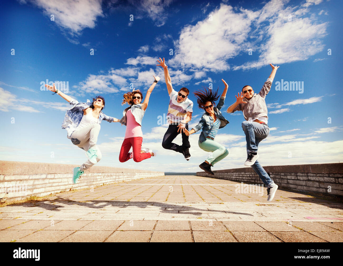 group of teenagers jumping Stock Photo - Alamy
