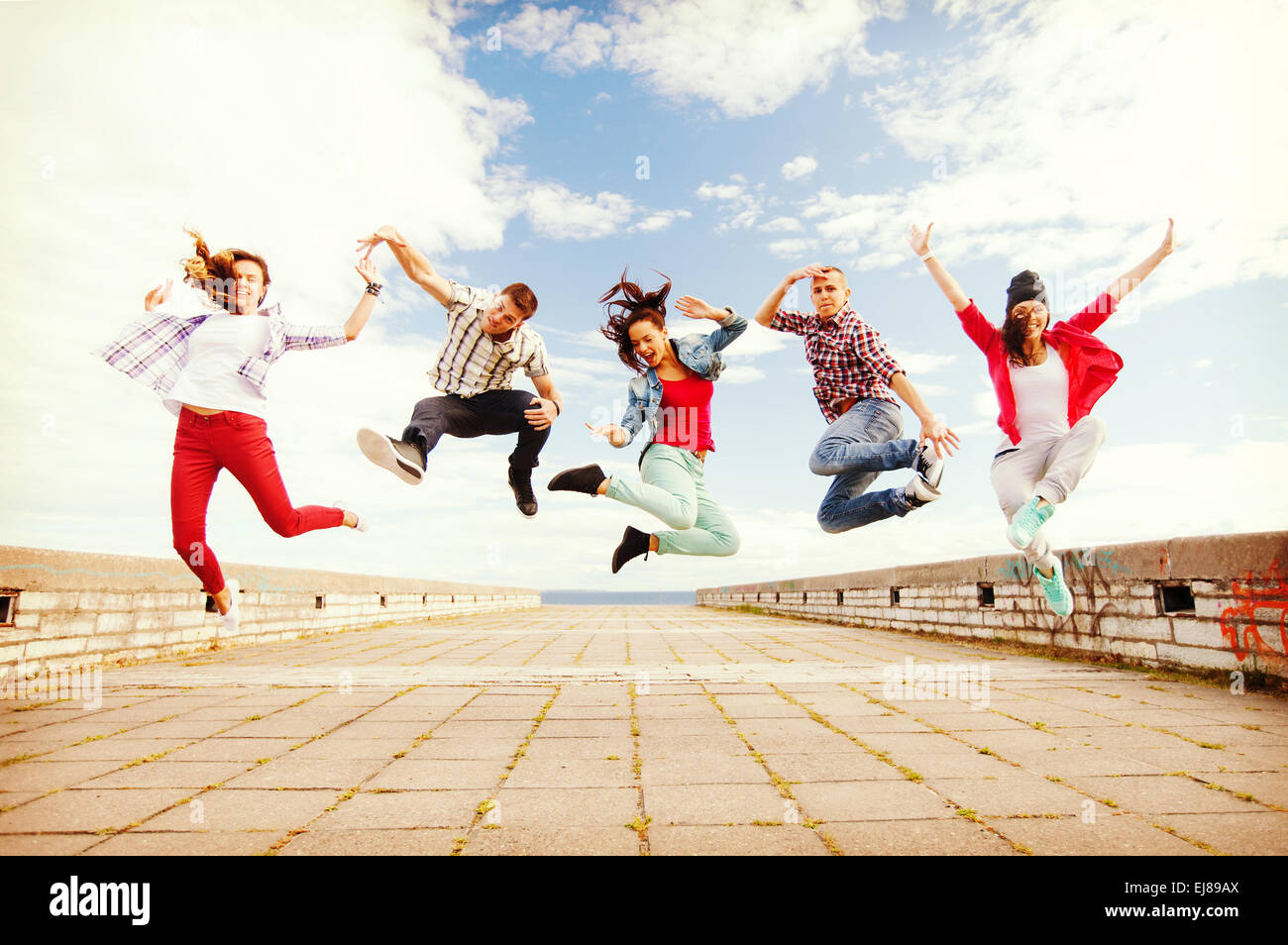 group of teenagers jumping Stock Photo - Alamy