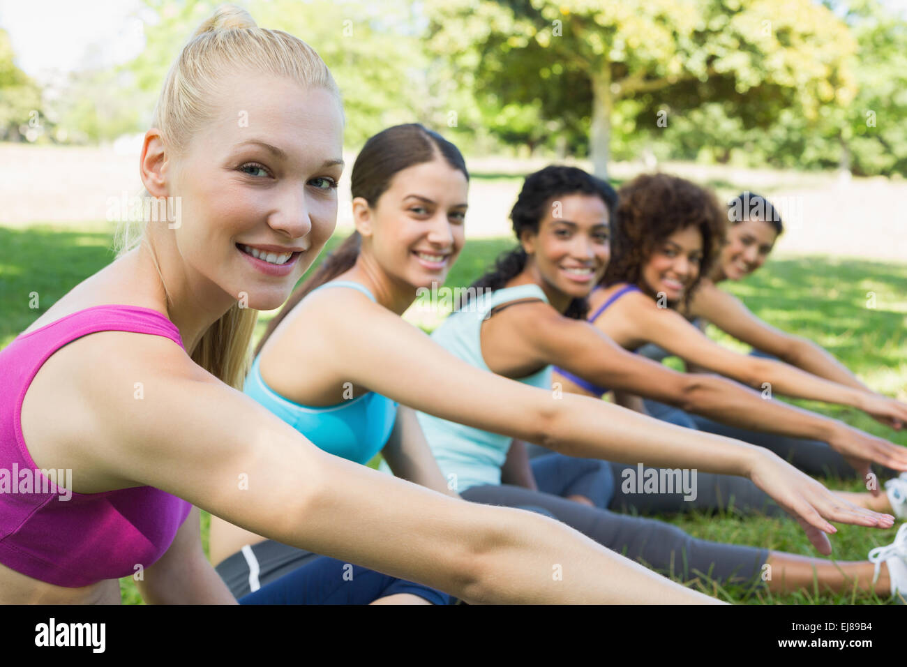 Friends doing stretching exercise at park Stock Photo - Alamy