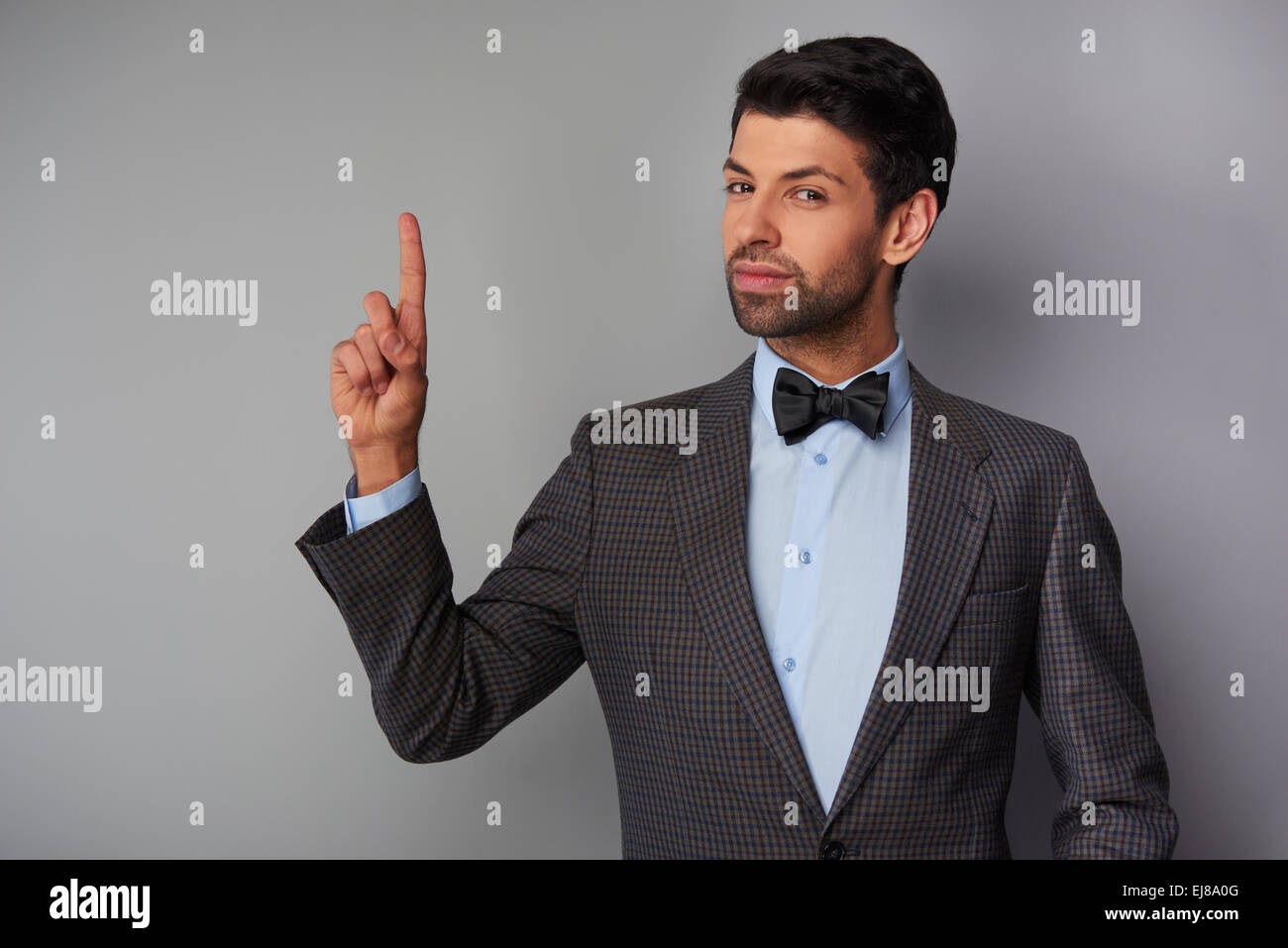 Man pointing up and looking at camera Stock Photo - Alamy