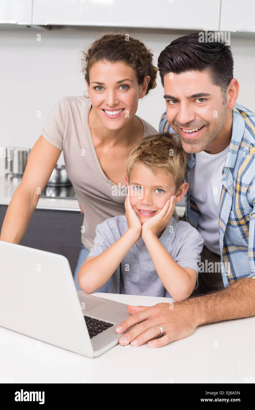 Smiling parents using laptop with their son Stock Photo - Alamy