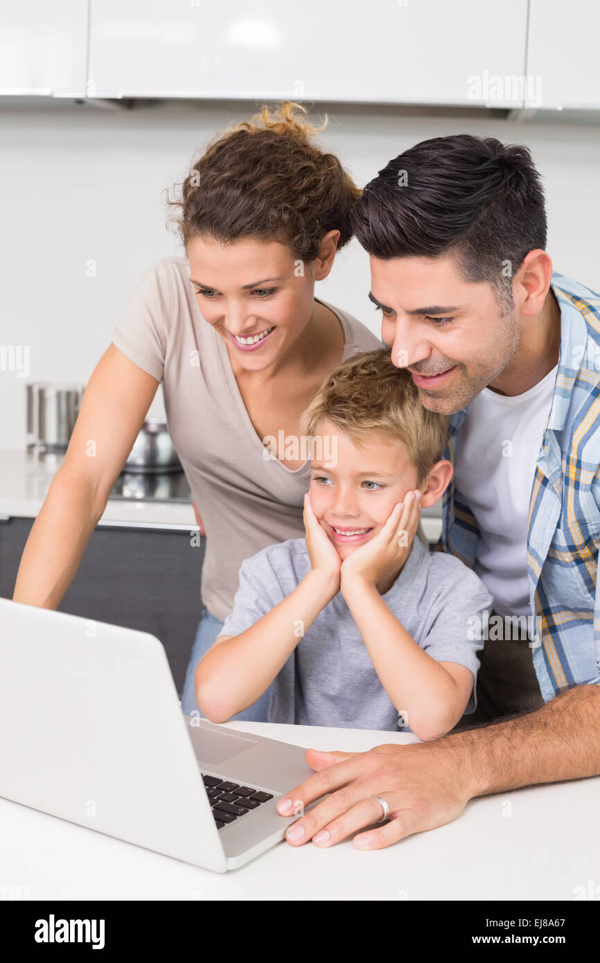 Parents using laptop with their son Stock Photo - Alamy