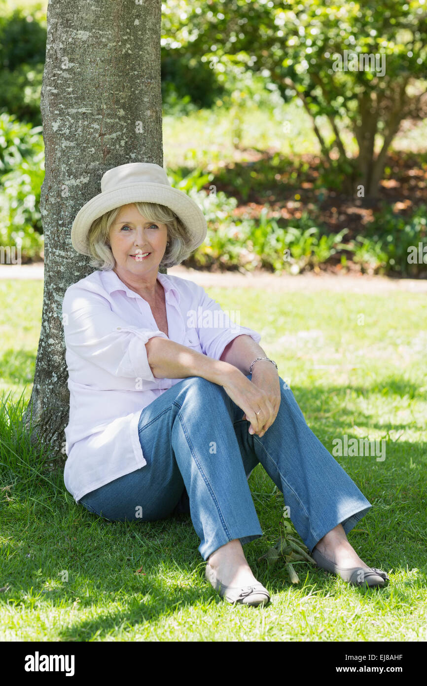 Woman sitting against tree trunk hi-res stock photography and images ...