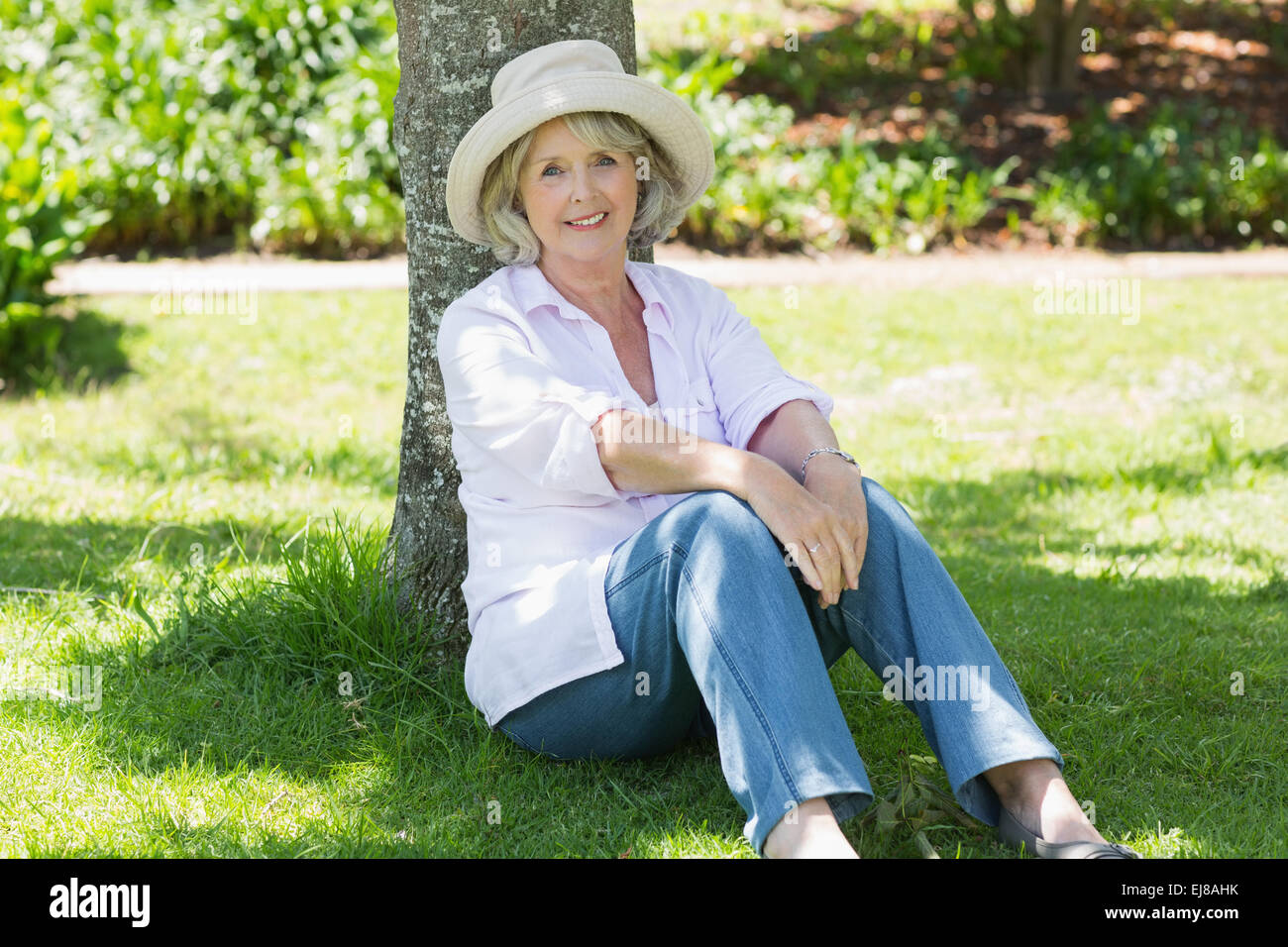 Woman sitting against tree trunk hi-res stock photography and images ...