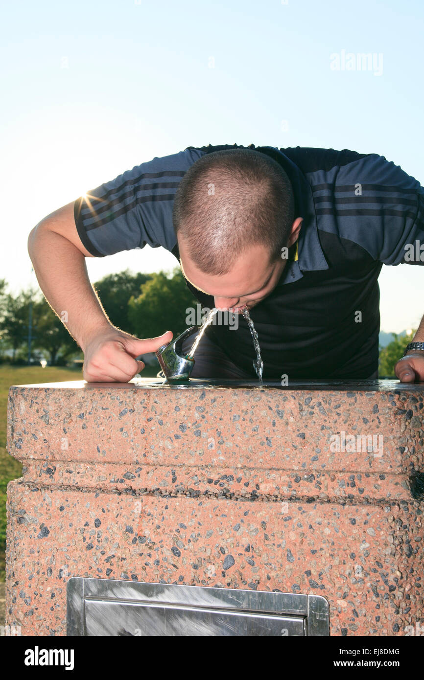 A Man drinking water from a fountain Stock Photo - Alamy