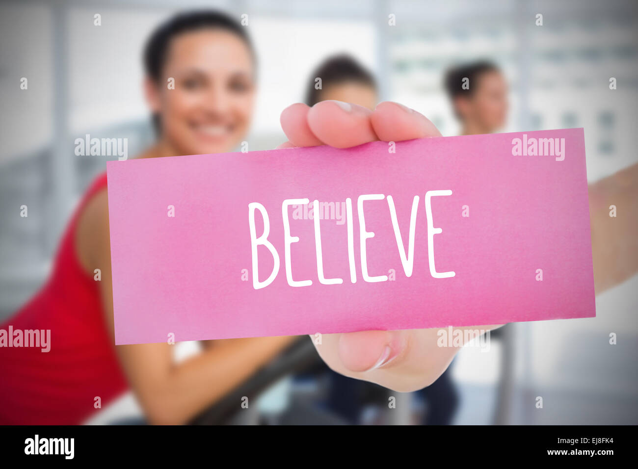Woman holding pink card saying believe Stock Photo - Alamy