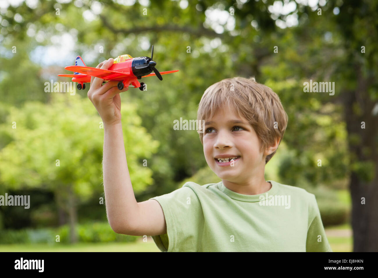 Boy playing with a toy plane at park Stock Photo - Alamy