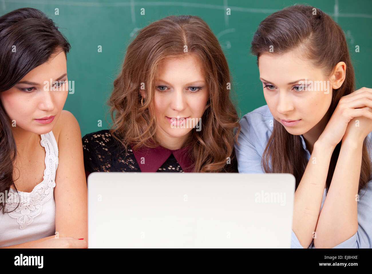 Three students and a notebook Stock Photo - Alamy