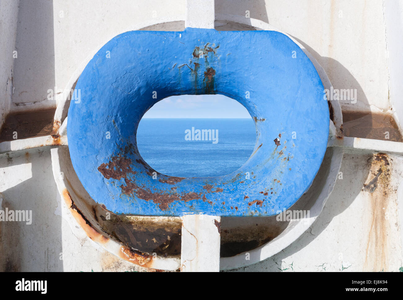 Blue bow hawse in old white rusted ship hull with sea landscape inside ...