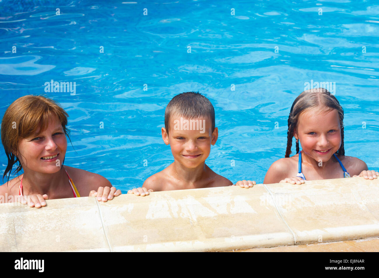 Family in the swimming pool Stock Photo - Alamy