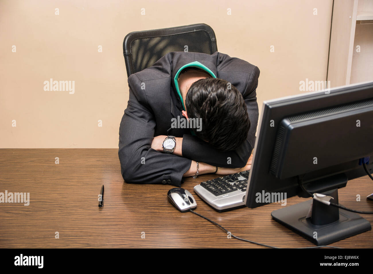 Overworked, tired young businessman sleeping on his desk in office, in ...