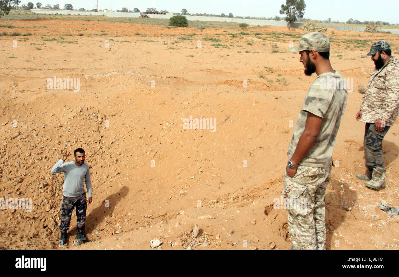 Tripoli, Libya. 23rd Mar, 2015. Libya Dawn fighters check a crater left ...