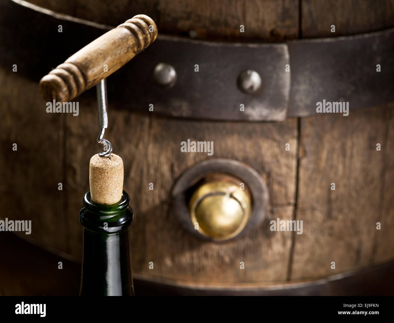 Opening of a wine bottle with corkscrew with wooden barrel on the ...