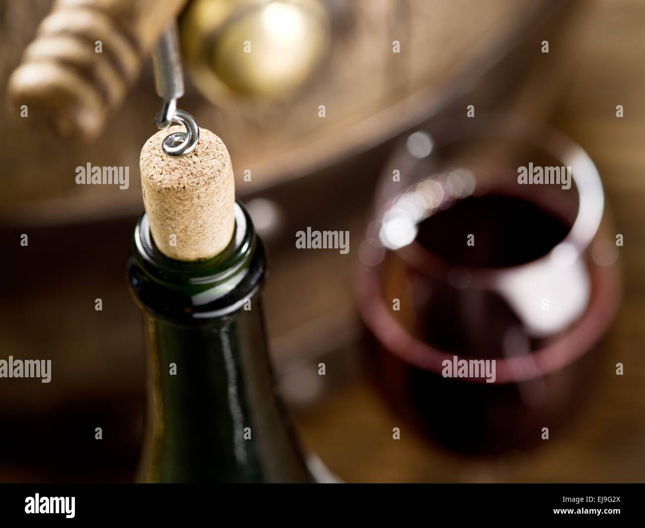 Opening of a wine bottle with corkscrew with wooden barrel on the ...