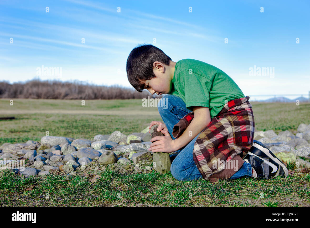 Boy plays with rocks Stock Photo - Alamy