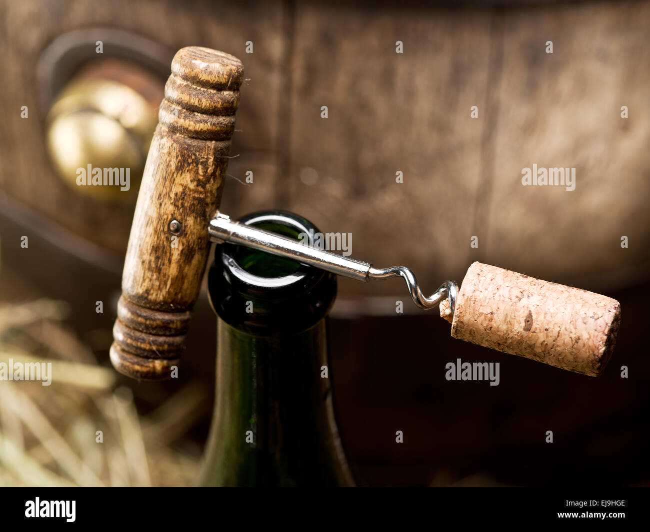 Opening of a wine bottle with corkscrew with wooden barrel on the ...