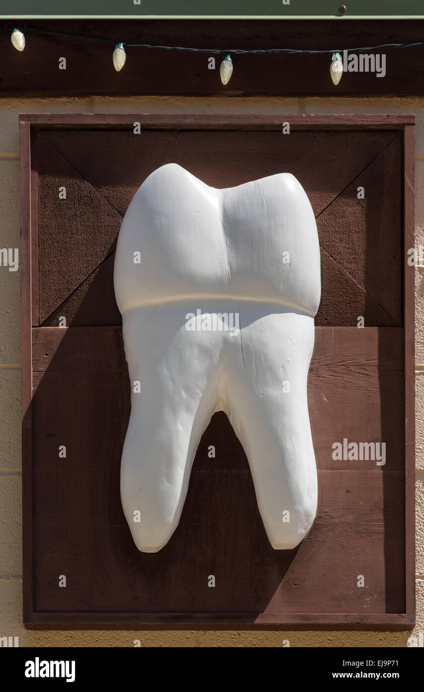 Large wooden tooth sign outside dentist Stock Photo - Alamy