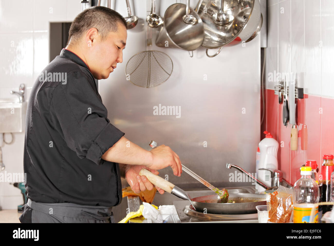 Chef cooking food in wok pan Stock Photo - Alamy