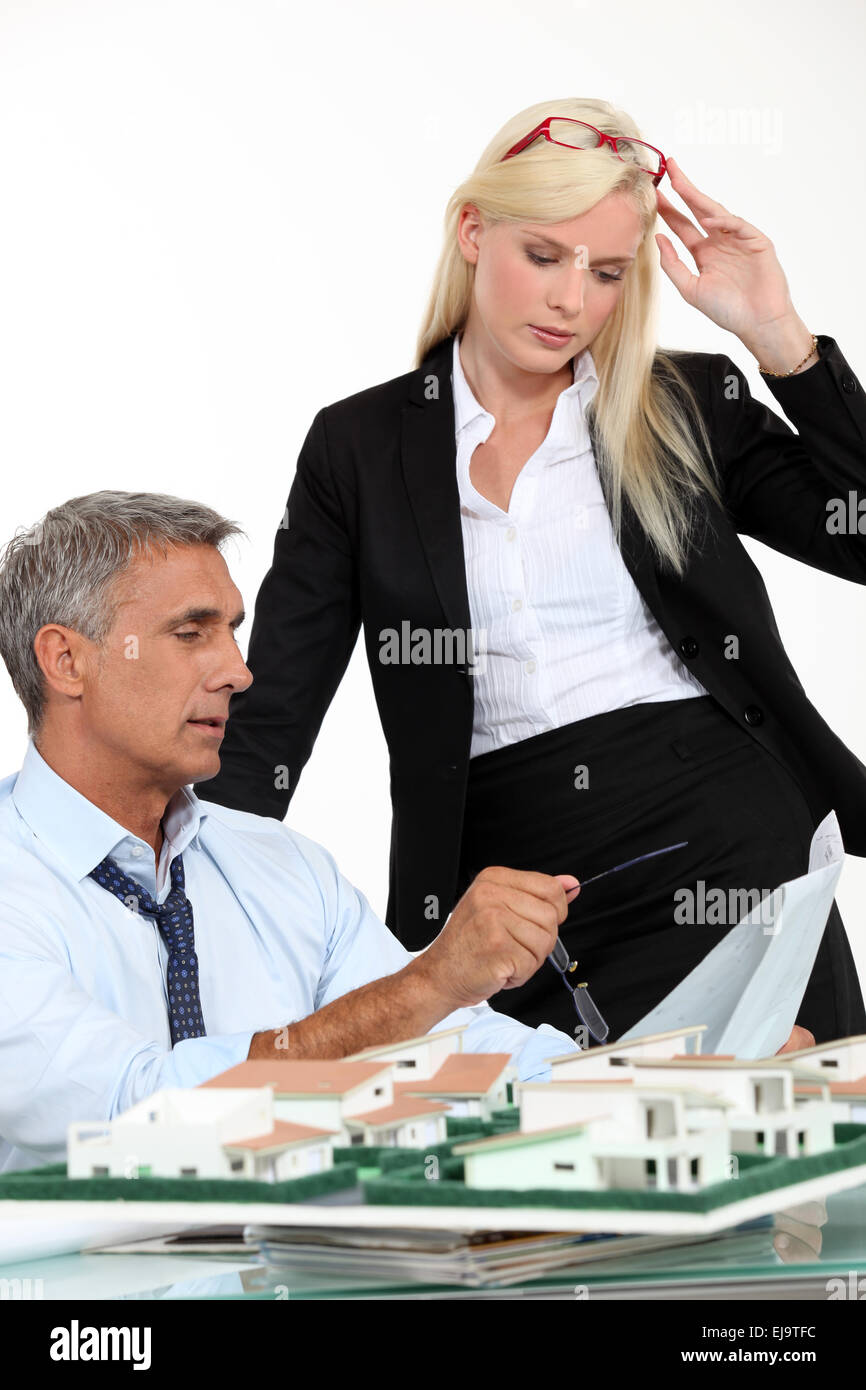 a boss and his female assistant thinking behind a subdivision model ...