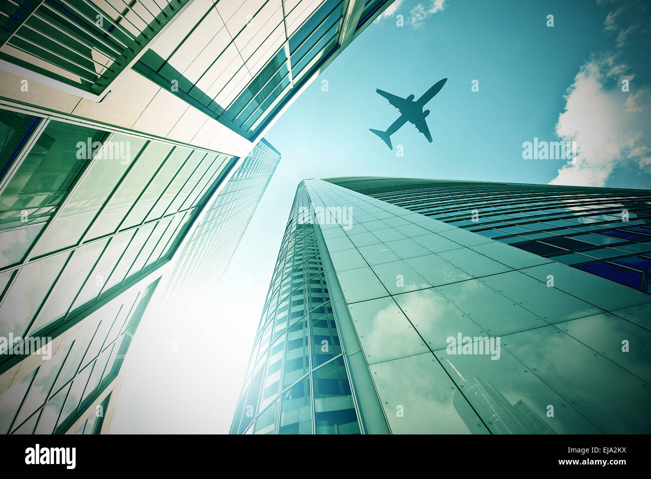 plane flying over modern office towers Stock Photo - Alamy