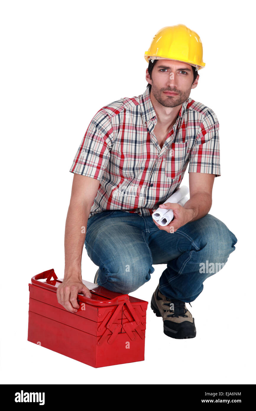 Builder carrying plans and a toolbox Stock Photo - Alamy