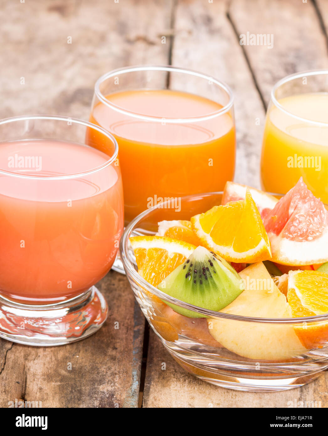 Pieces of fresh fruits in glass bowl with juice. Healthy breakfast ...