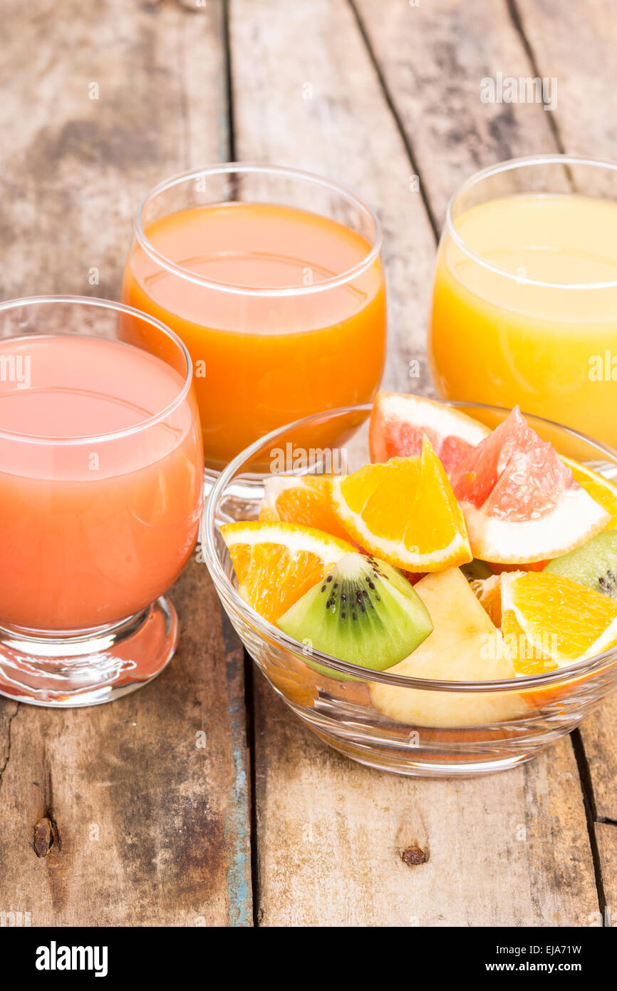 Fresh organic food background. Pieces of fruits with juice in glass on ...