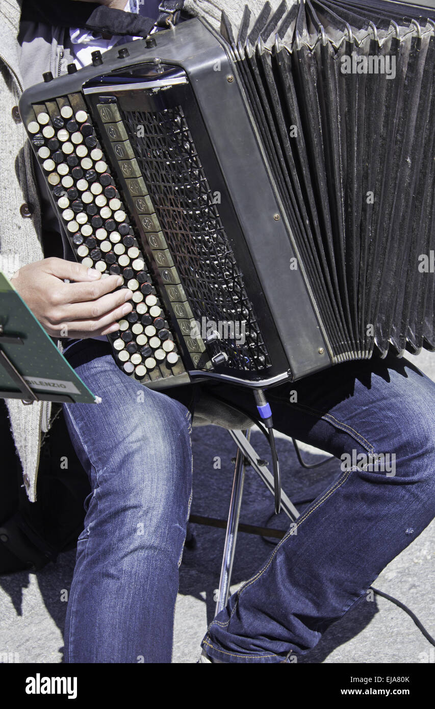 Musician with accordion playing in the street, and musical ...
