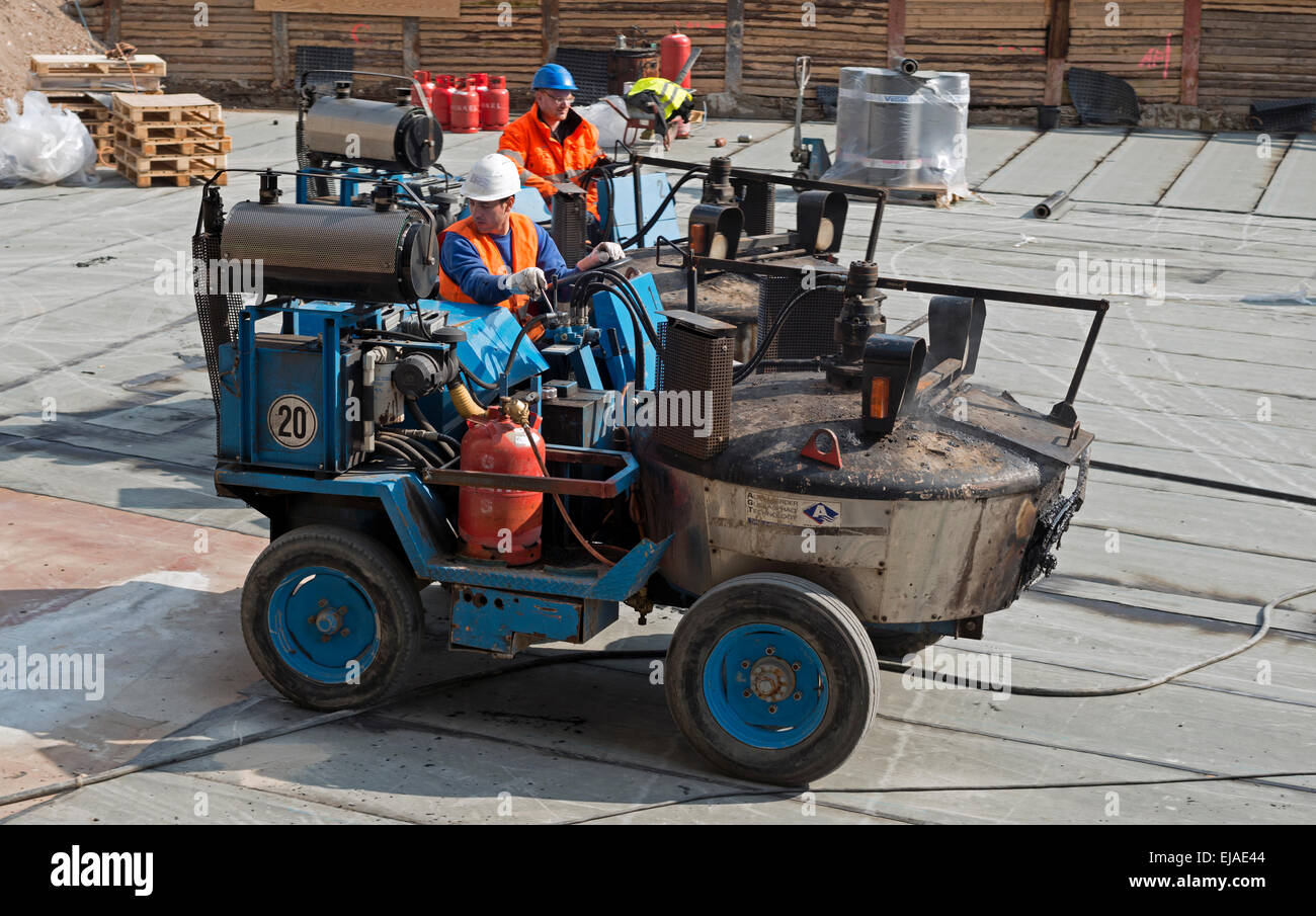 Self-propelled asphalt delivery vehicles working in tandem on an ...