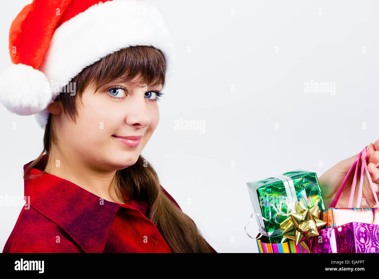 Young blue-eyed beautiful girl in santa hat with presents Stock Photo ...