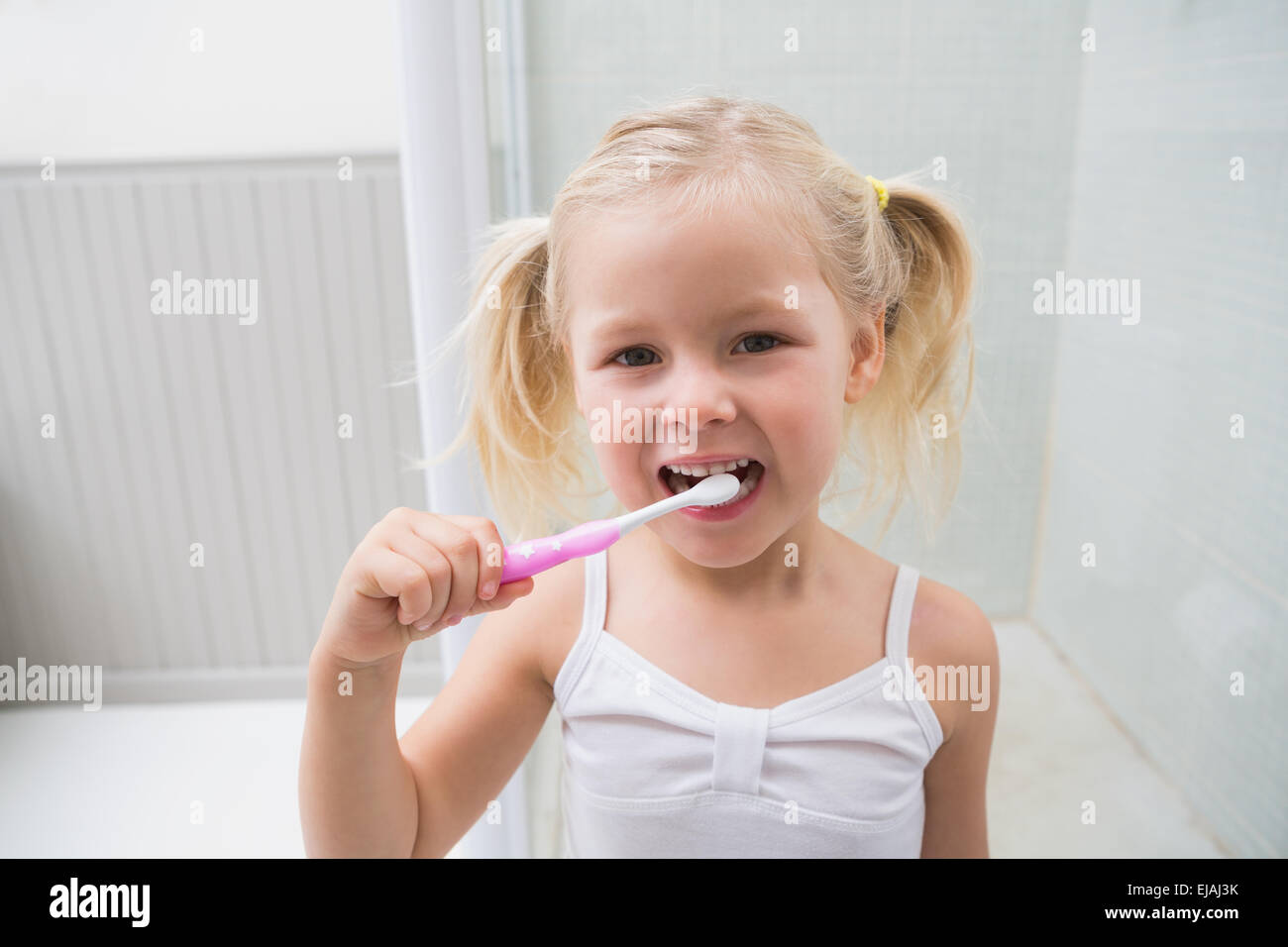 Cute girl brushing her teeth Stock Photo - Alamy