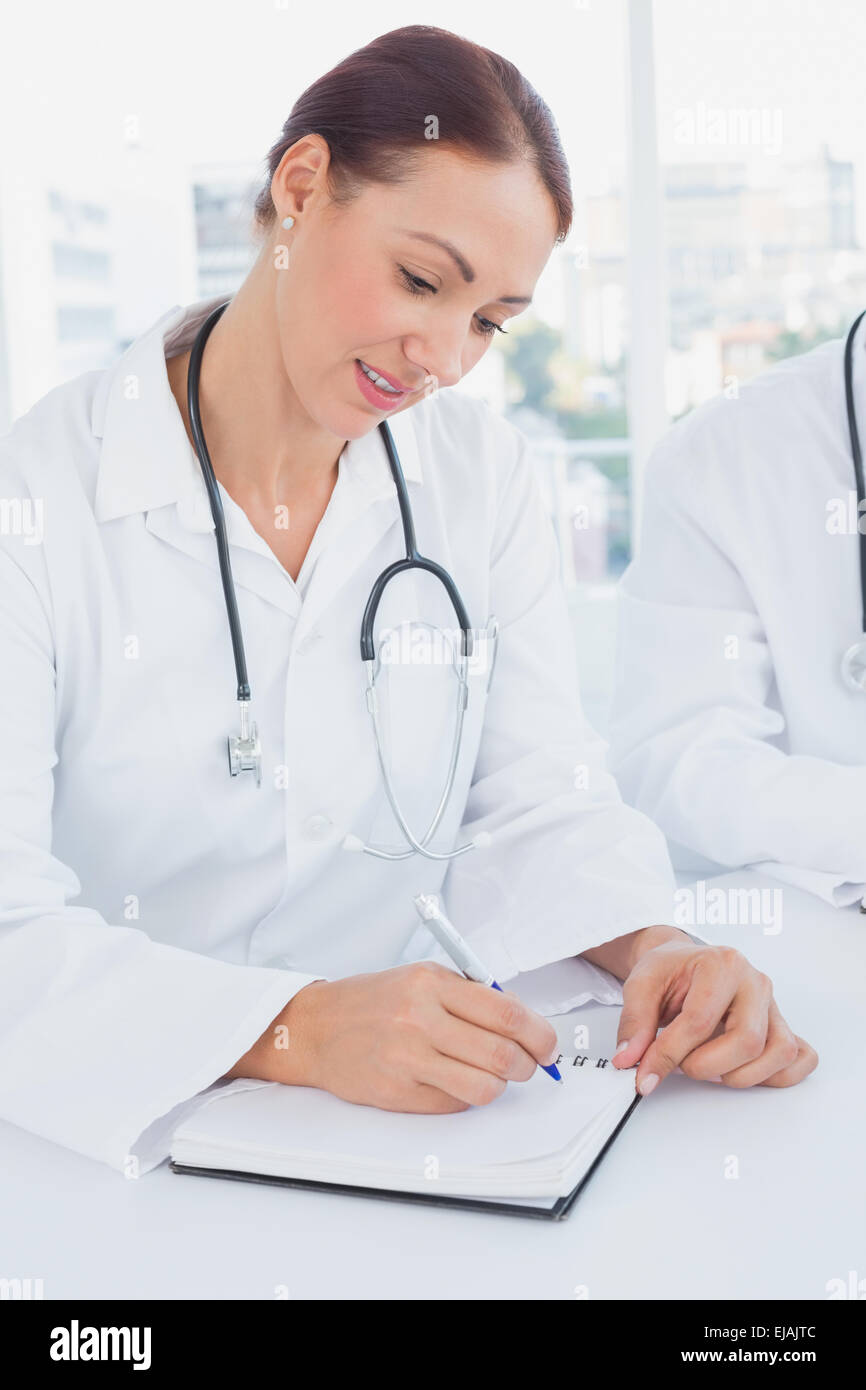 Doctor sitting and taking notes Stock Photo - Alamy