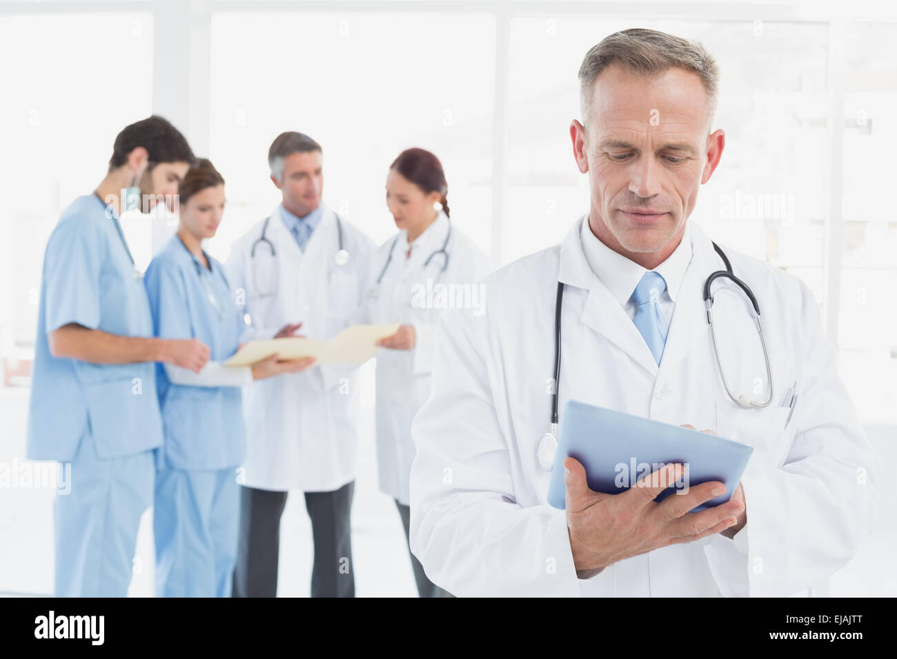Serious doctor using his tablet Stock Photo - Alamy