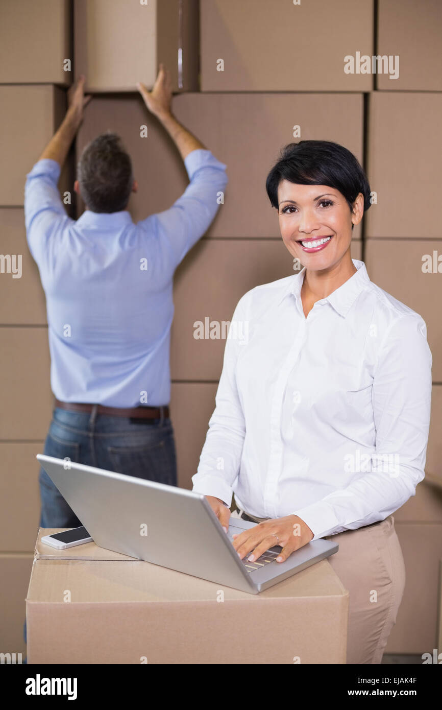 Pretty warehouse manager using laptop Stock Photo - Alamy