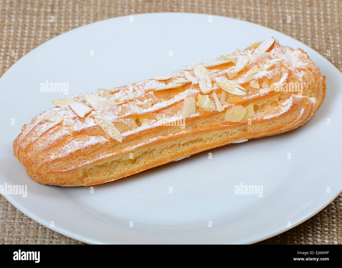 Eclair with a cream on a plate Stock Photo - Alamy