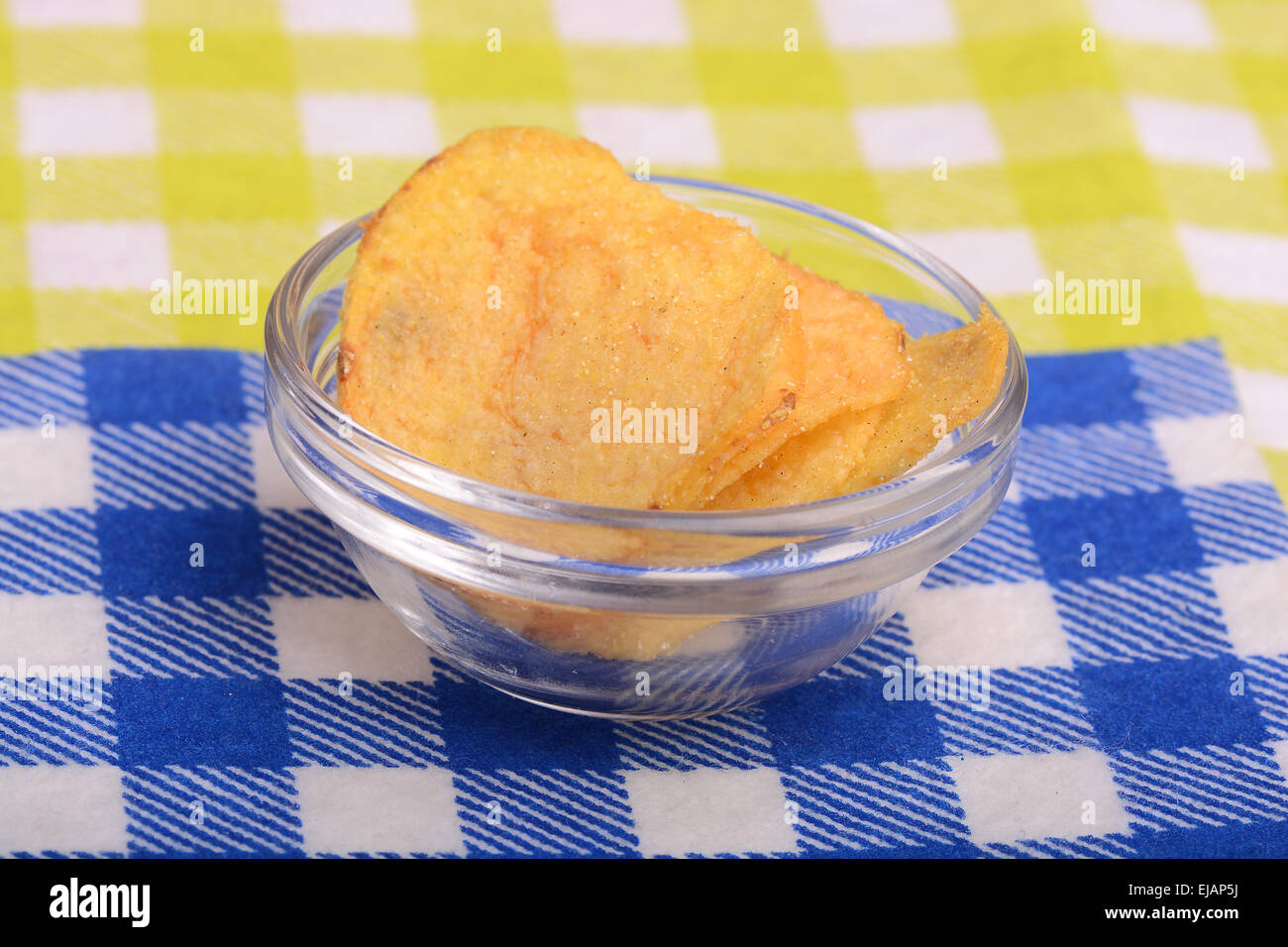 Close-up of fresh, crispy potato chips in a wooden bowl on a white ...