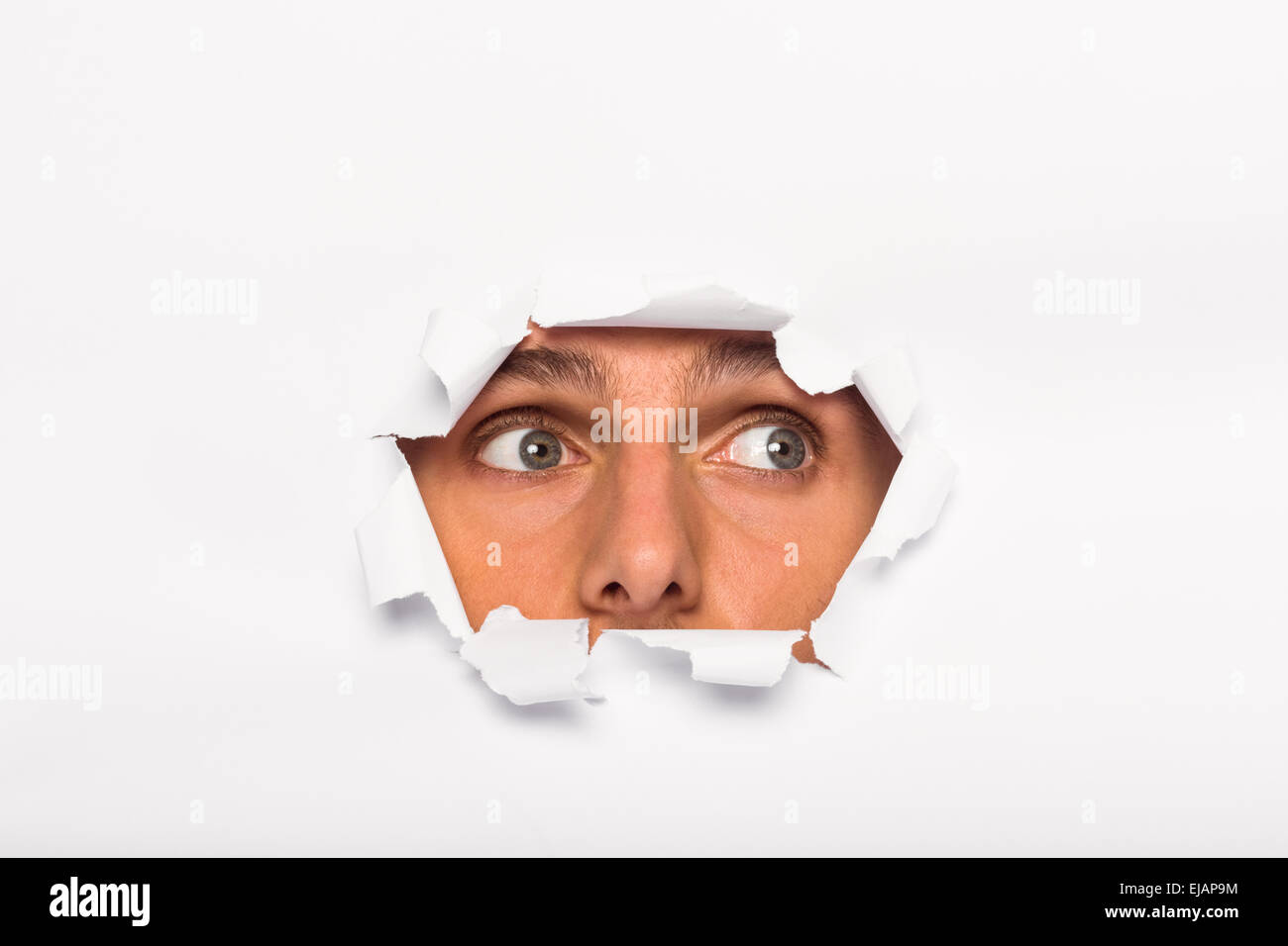 Man peeking through torn paper hi-res stock photography and images - Alamy