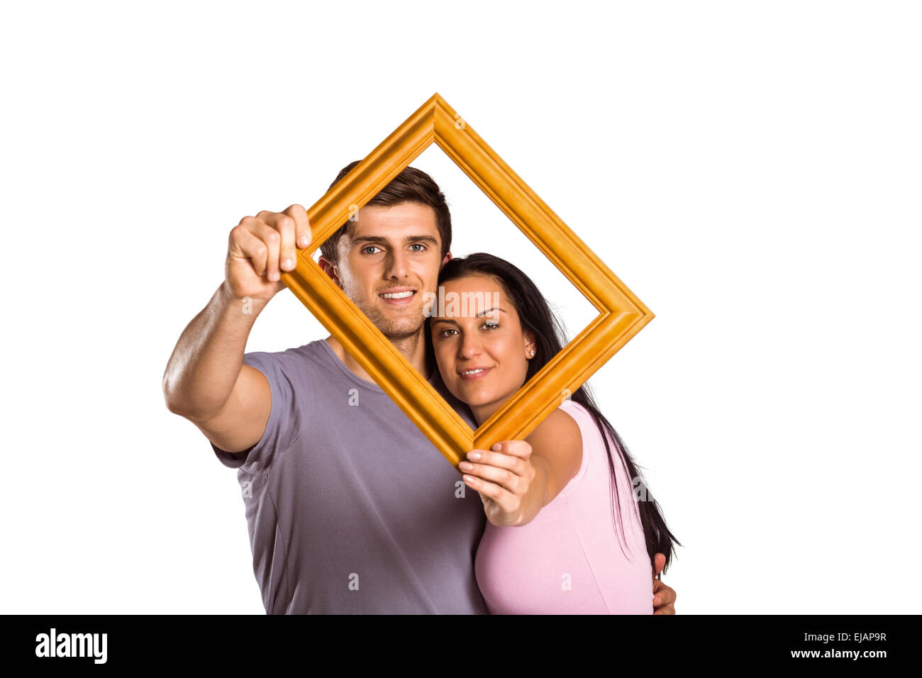Young couple holding up frame Stock Photo - Alamy