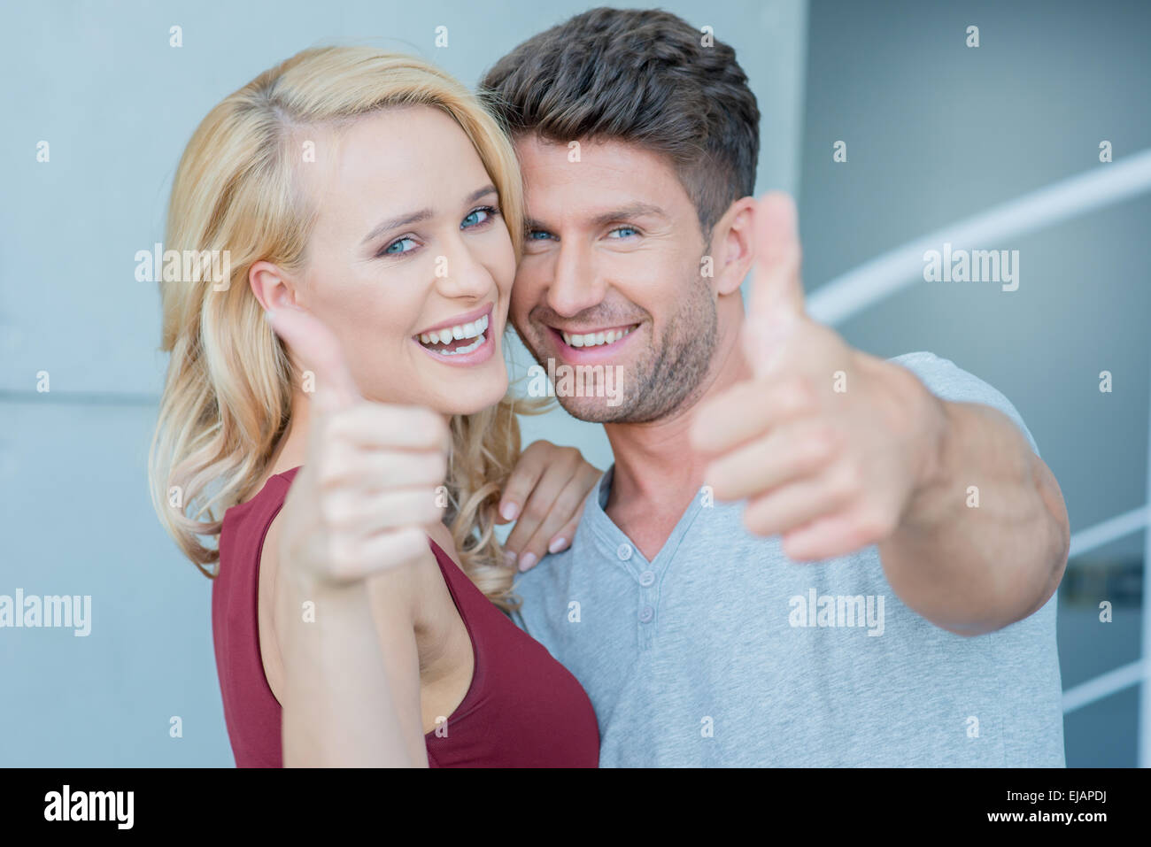 Happy laughing couple giving a thumbs up Stock Photo - Alamy