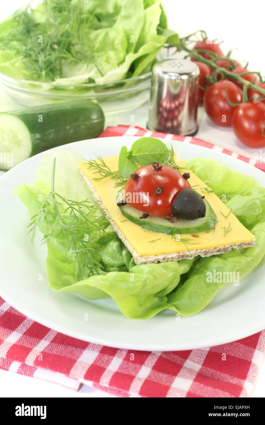 crisp bread with cheese, lettuce and ladybug Stock Photo - Alamy