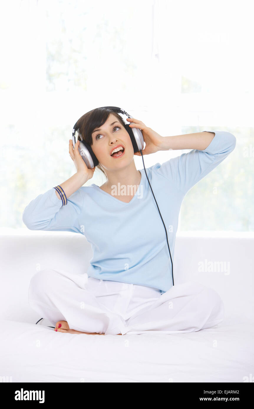 Sitting Woman Wearing Headphones and Singing Stock Photo - Alamy