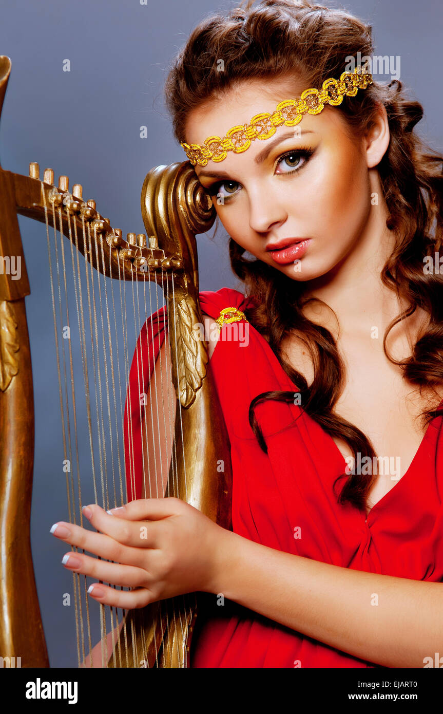 beautiful young girl playing the harp Stock Photo - Alamy