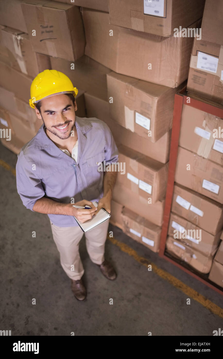 Worker with clipboard in warehouse Stock Photo - Alamy